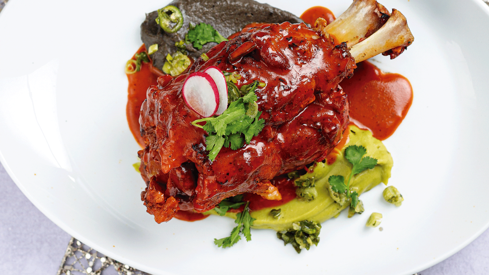 Chamorro de cerdo estofado en salsa de achiote y vino blanco